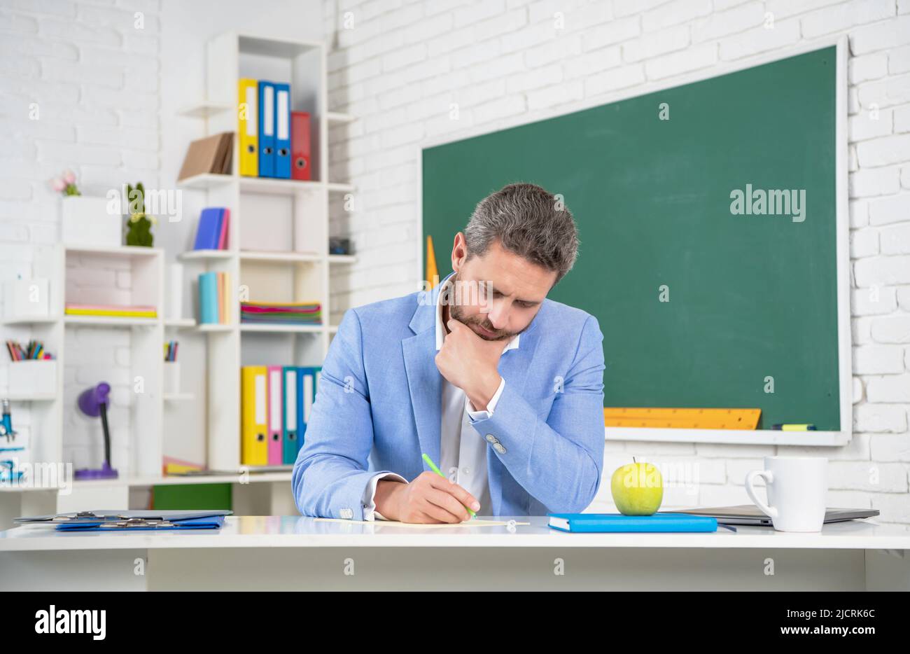 busy school teacher in classroom at blackboard Stock Photo - Alamy