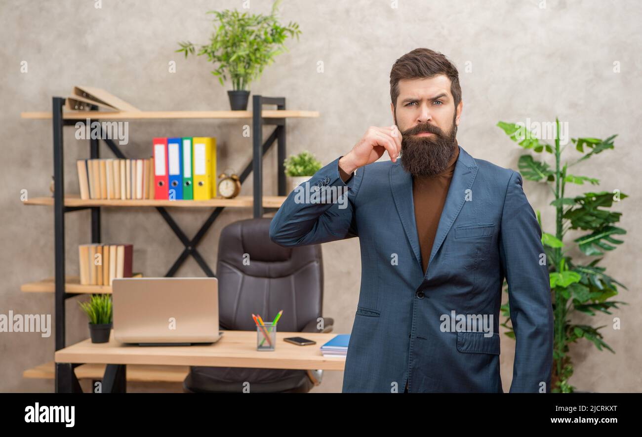 serious bearded boss wear suit in the office with copy space touch his ...