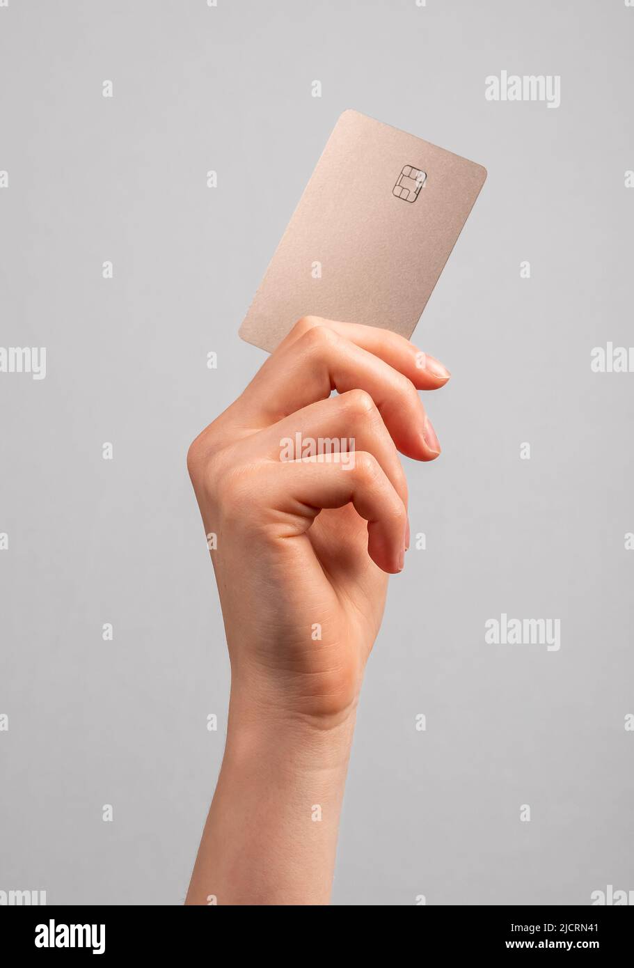 Hand holding credit card mockup with chip. Buying at stores, making transactions at terminals ...