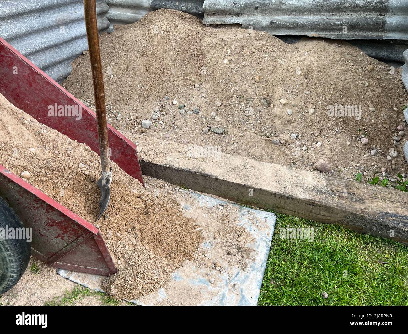 A cart filled with sand with a shovel for transporting and mixing ...