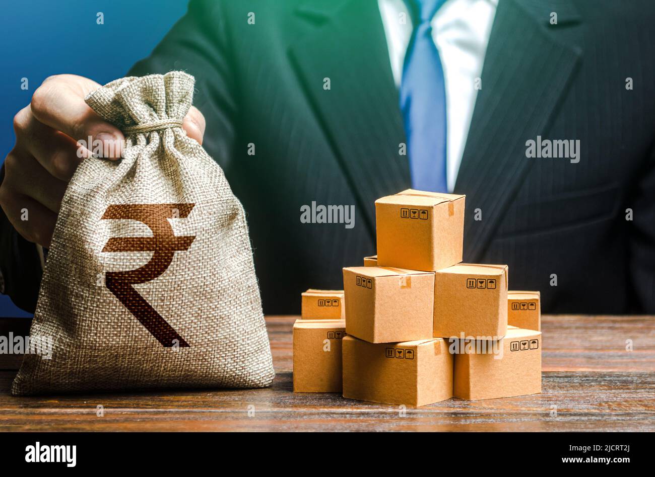 Businessman holds indian rupee money bag and boxes with goods. Import ...