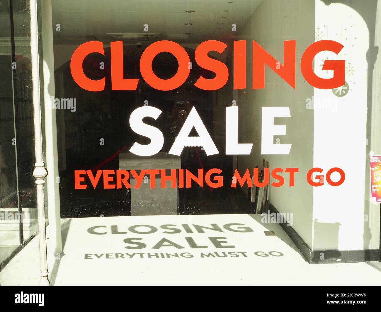 Store closing sale sign with shadow in high street shop window display ...