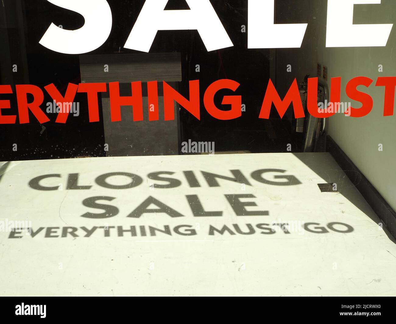 Store closing sale sign with shadow in high street shop window display ...