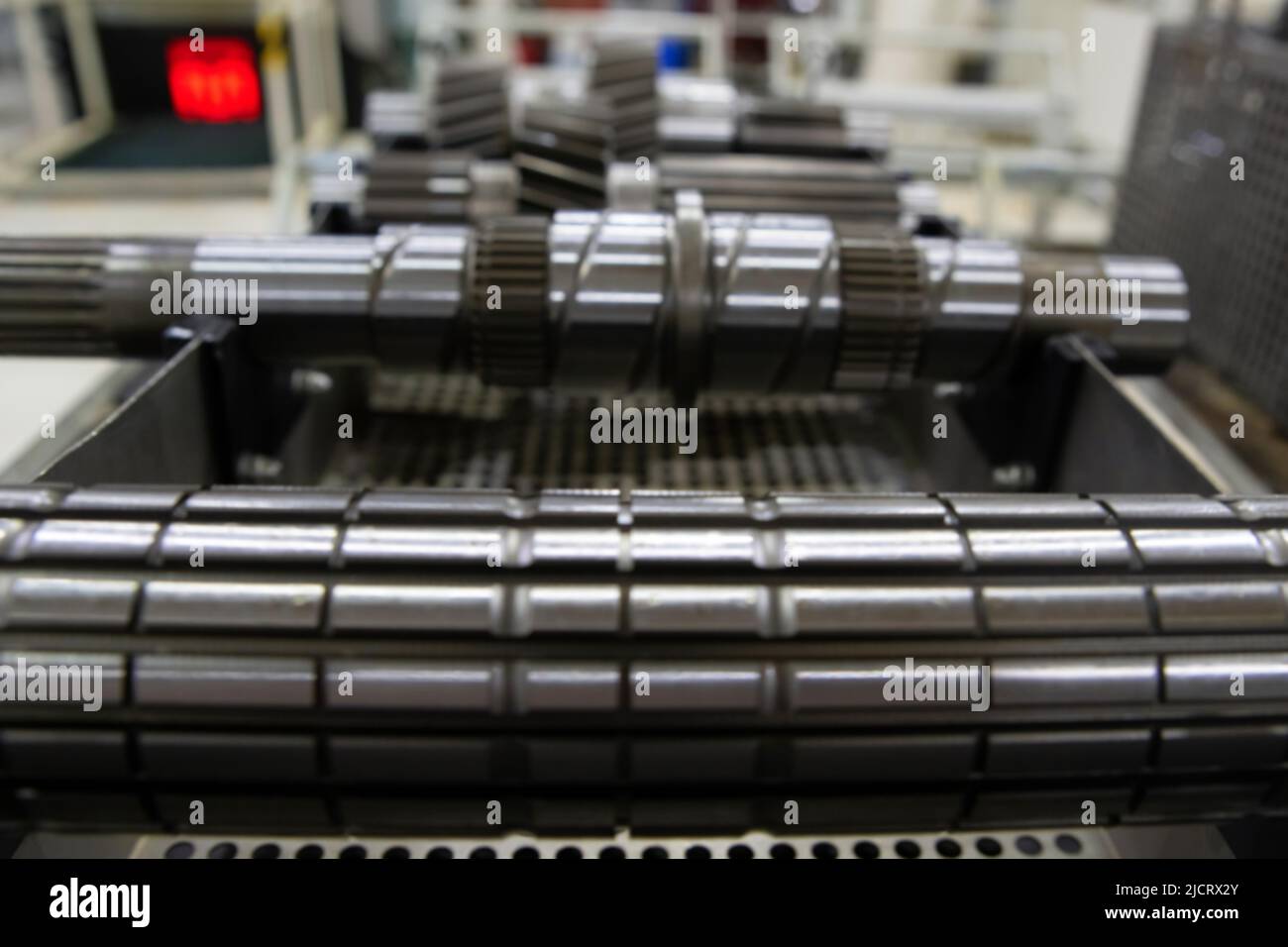 Blurred image of brandnew shaft gear for transmission. Spare parts in ...