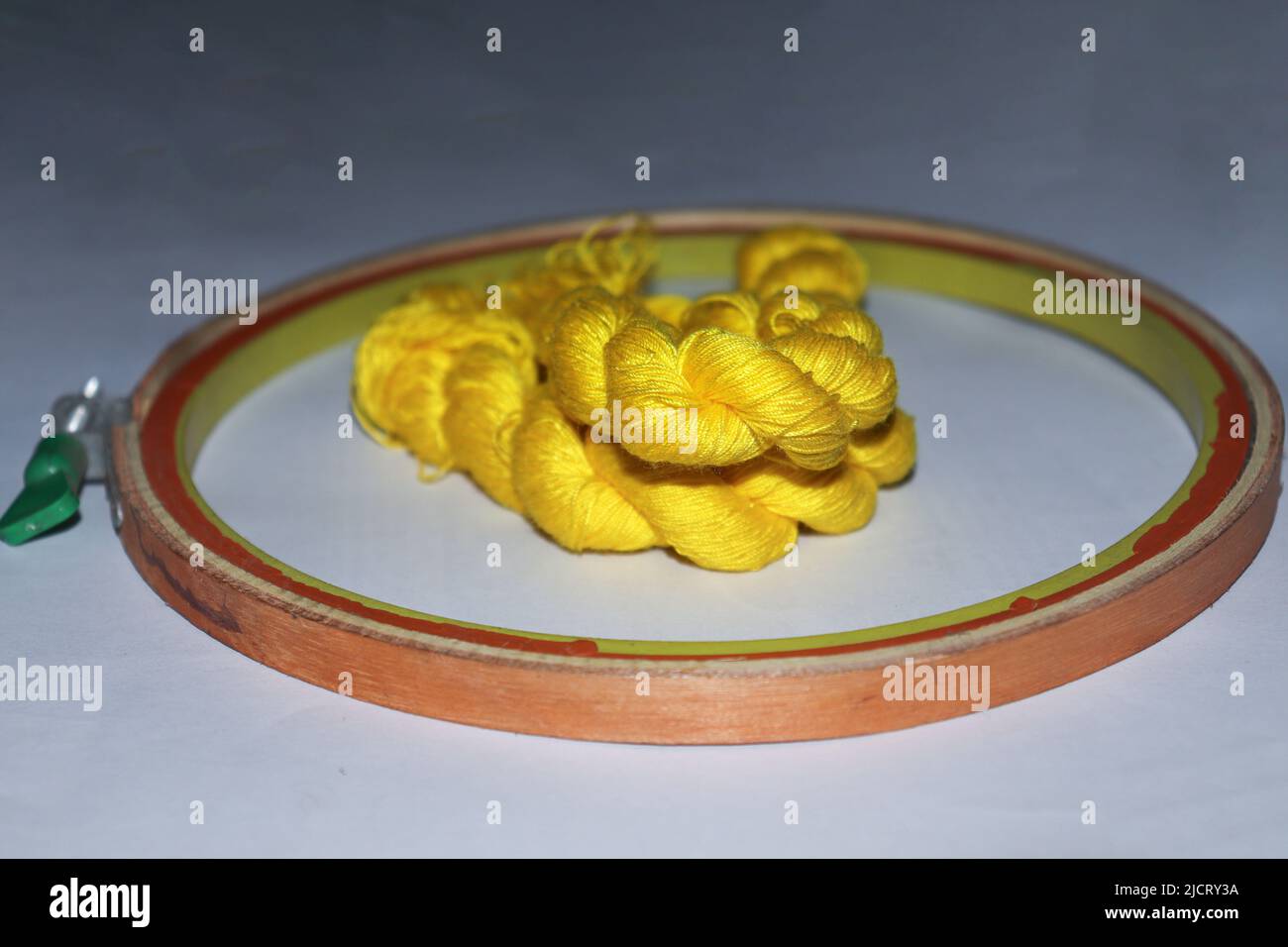 yellow colored wool yarn bunch with hand wood circle frame for ...