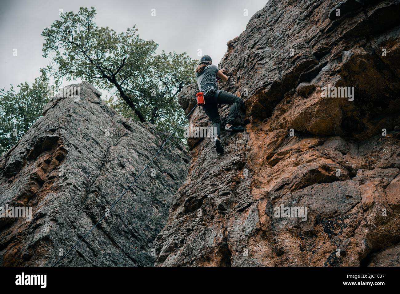Young man climbing up a cliff at Lake Mineral Wells State Park Stock ...