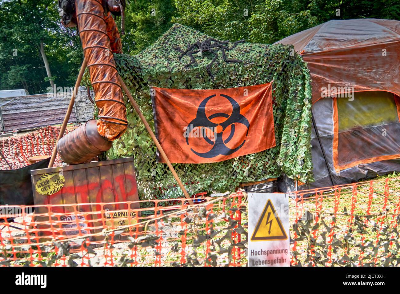Tent with a camouflage net and a loge with the warning of a biohazard ...