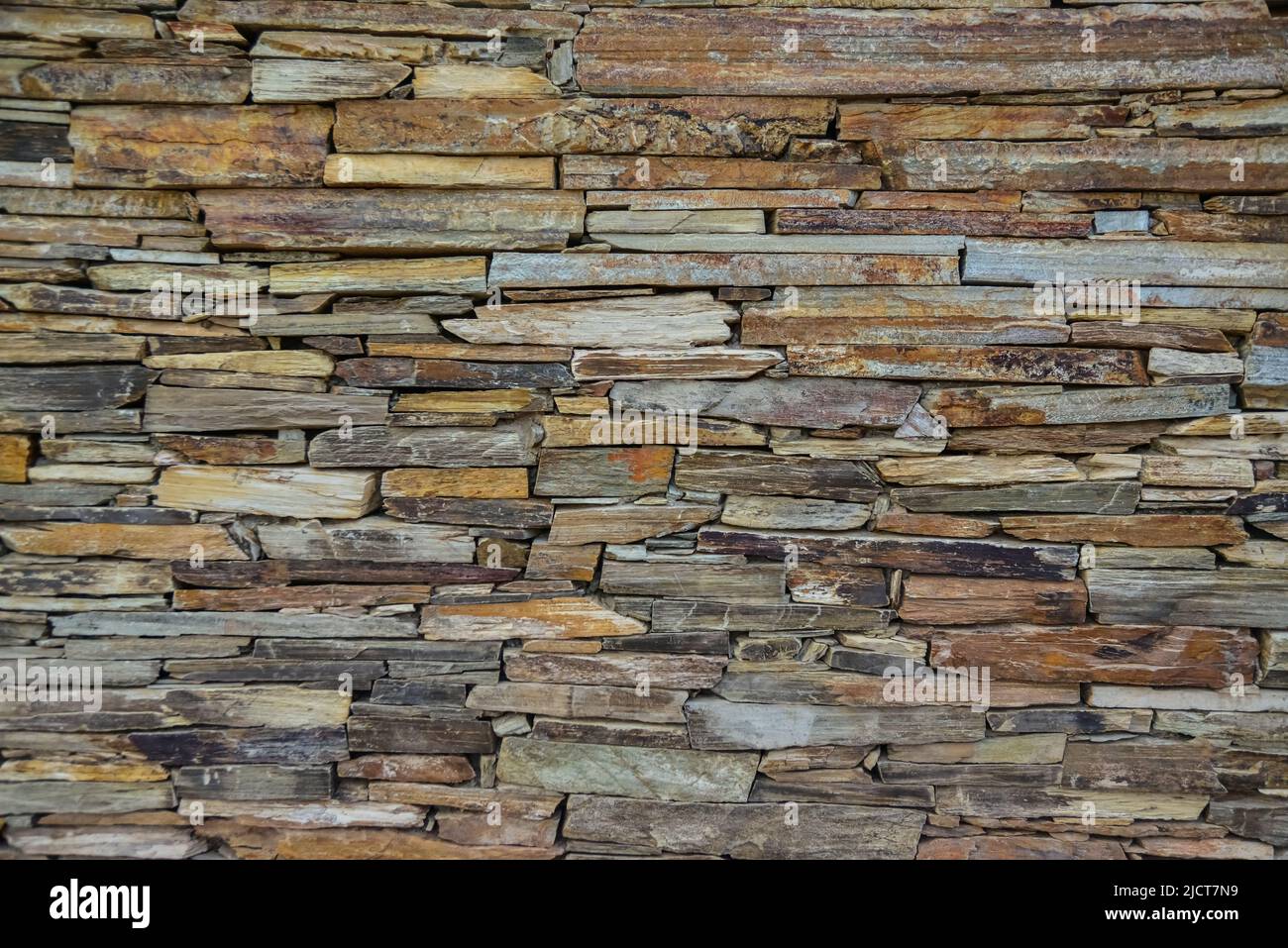 Stone wall made of multi-colored layered natural sandstone Stock Photo ...