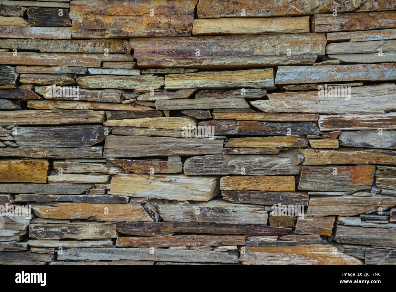 Stone wall made of multi-colored layered natural sandstone Stock Photo ...
