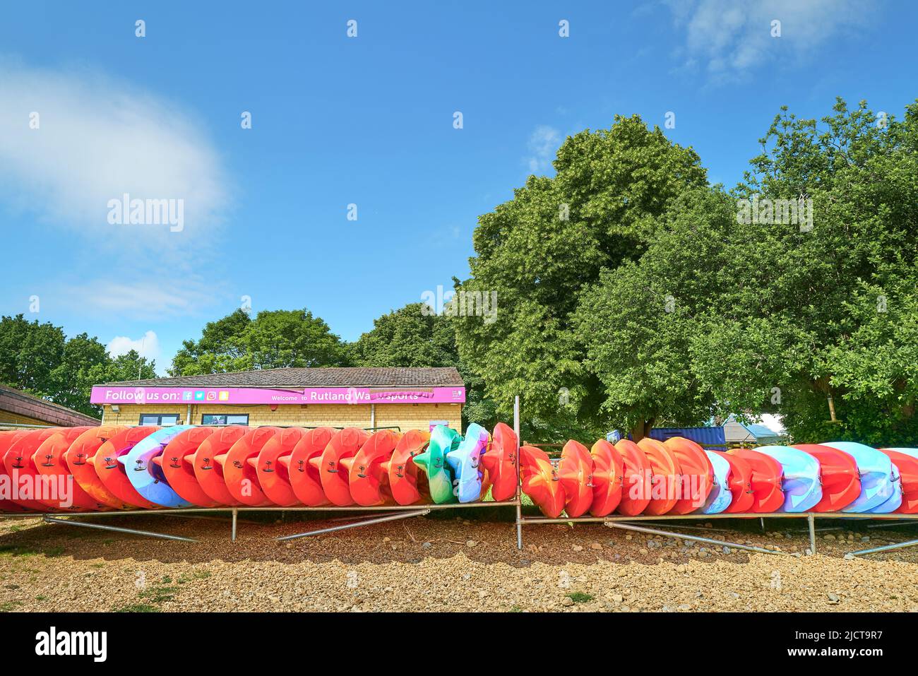A row of open top canoes lined up on the shore of a lake Stock Photo ...