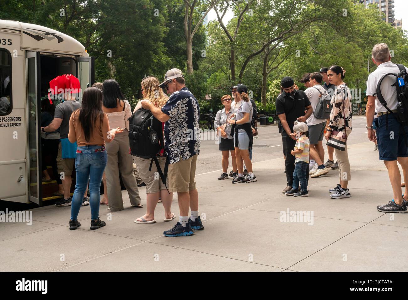 A tour group boards their bus in the Flatiron neighborhood in New York ...