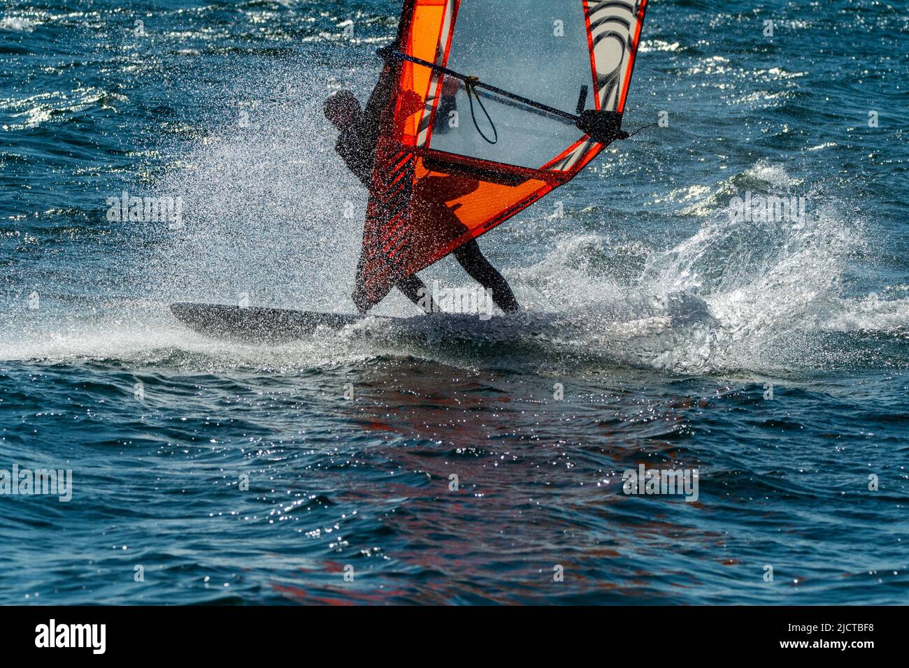 Windsurfer is practicing on this beautiful windy spring day. He is ...