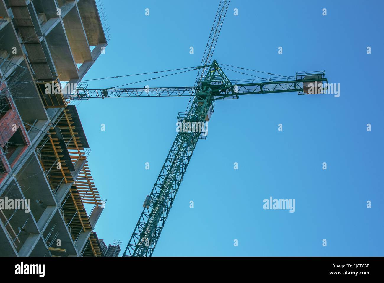 A crane lifts concrete for a modern metal-concrete structure of a ...