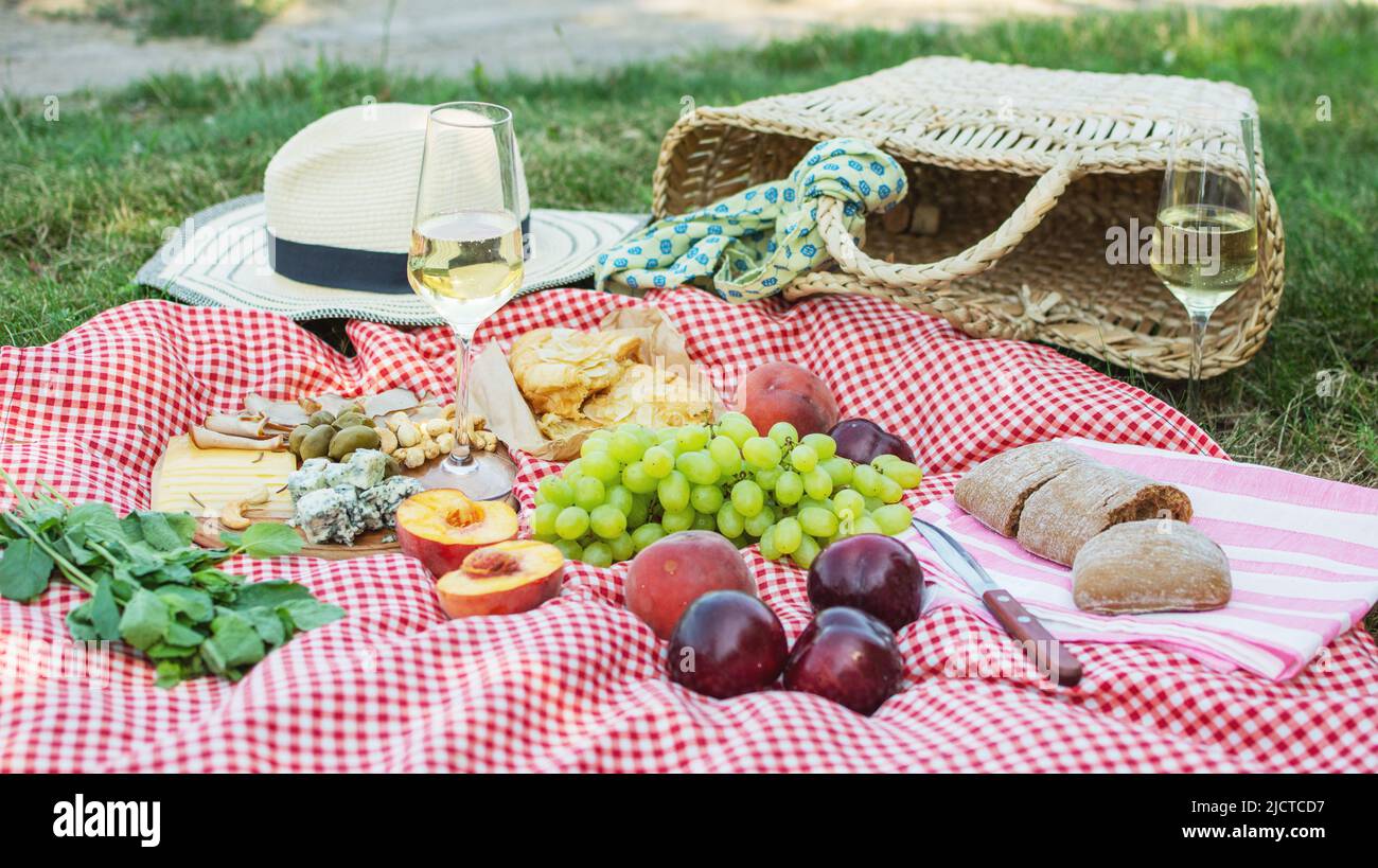 Summer picnic in the park on the grass. Wine, fruit and croissants ...