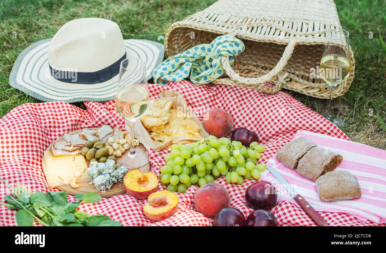 Summer picnic in the park on the grass. Wine, fruit and croissants ...