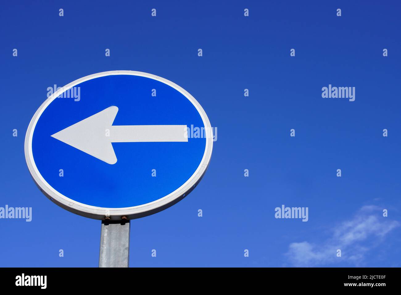 round traffic sign with arrow over blue sky Stock Photo - Alamy