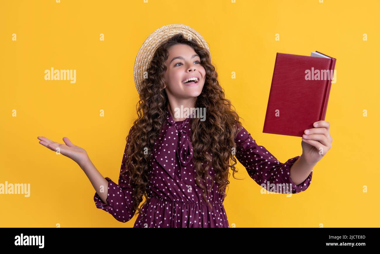 smiling child with frizz hair recite book on yellow background Stock ...
