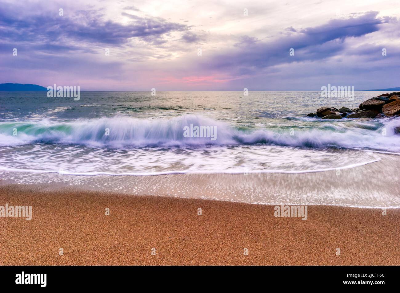 A Sunrise Back Lit Ocean Wave Is Breaking On The Beach Shore In A ...