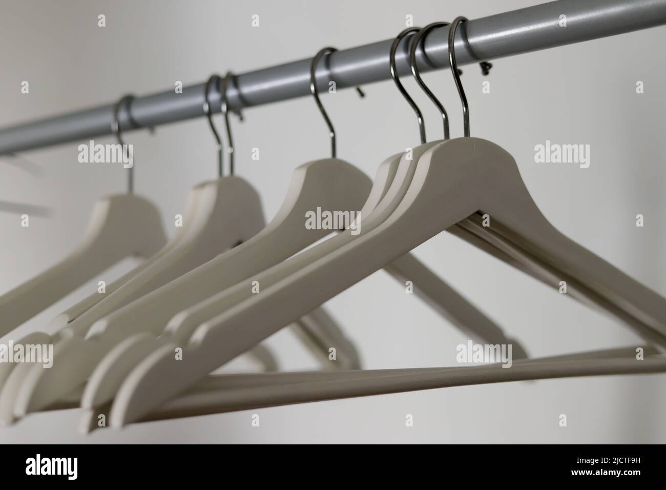empty white wooden hangers hung on a rack Stock Photo - Alamy