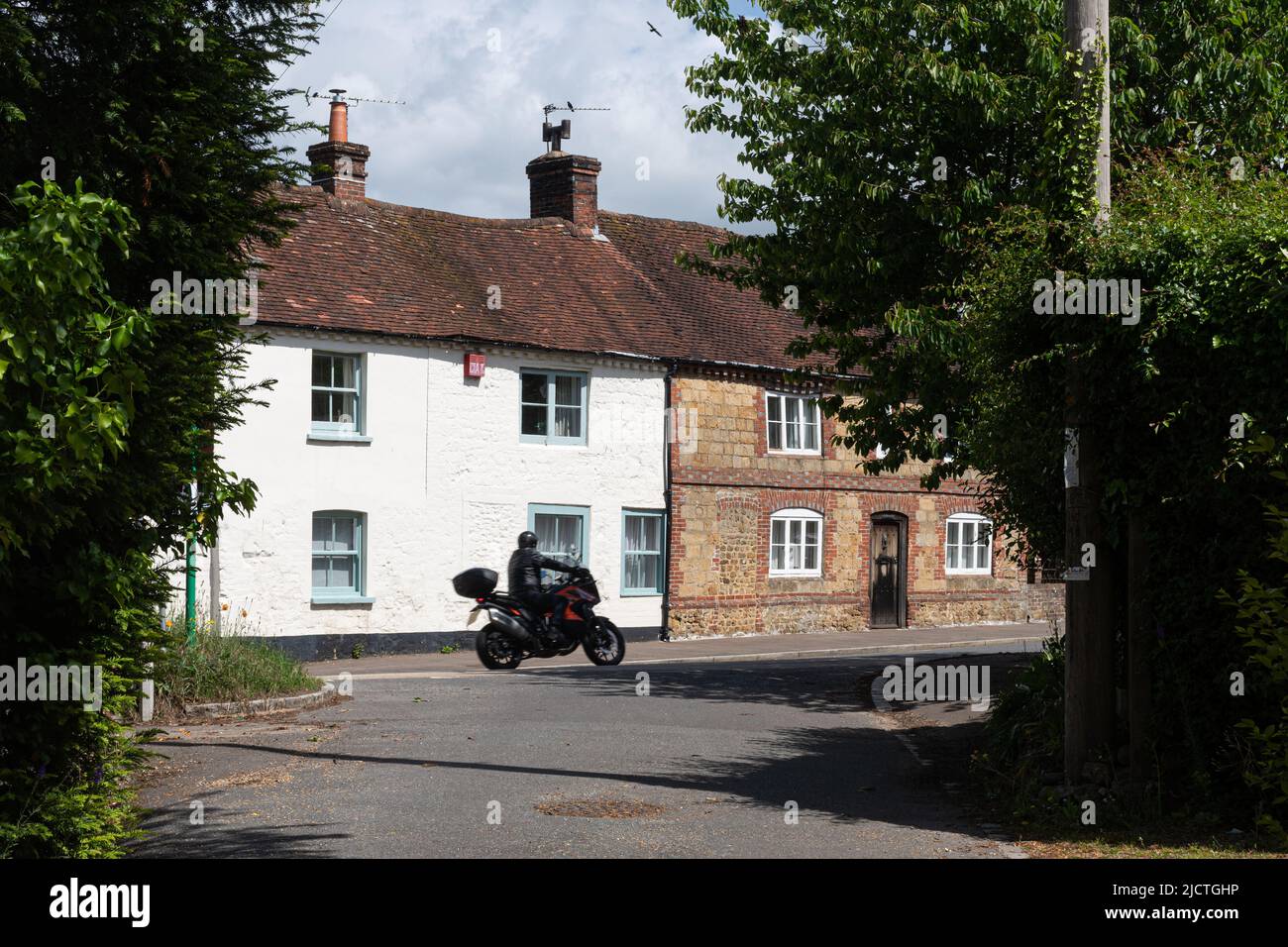 Rogate village in West Sussex, England, UK, with motorbike driving past ...