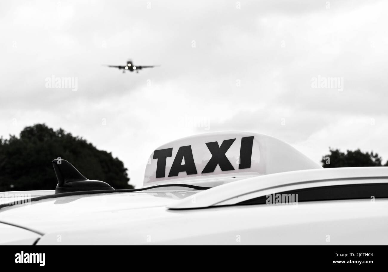 Close up view of the sign on top of a taxi at an airport with a plane ...