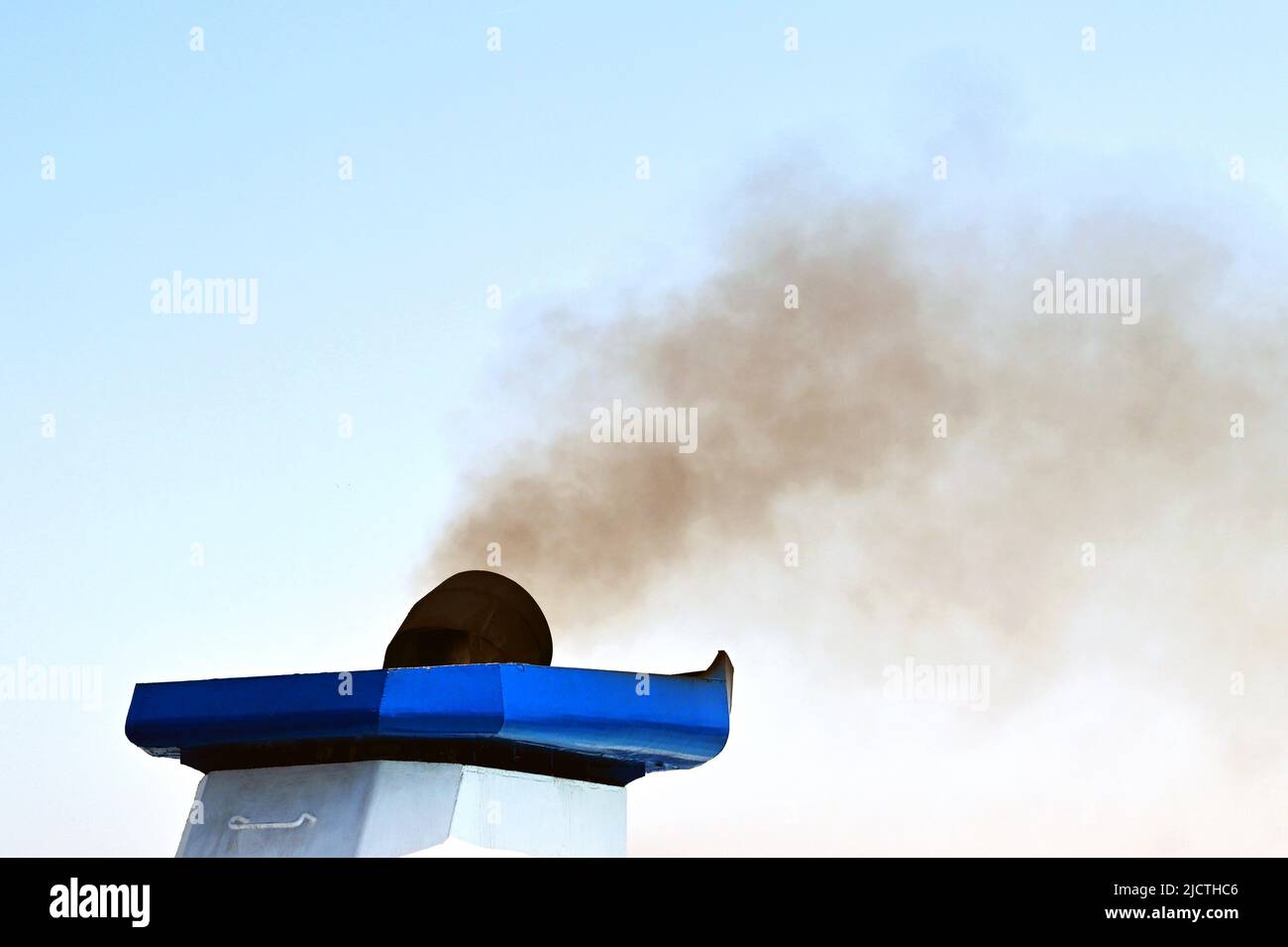 Black smoke emerging from the funnel of a ferry. No people. Copy space ...
