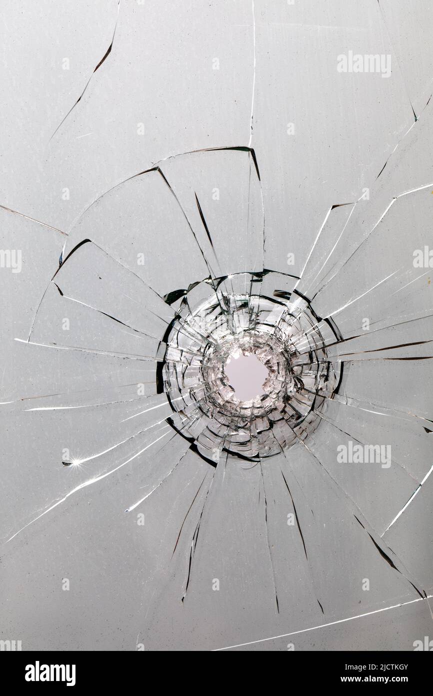 Bullet hole in the rock. Broken window, cracks Stock Photo - Alamy