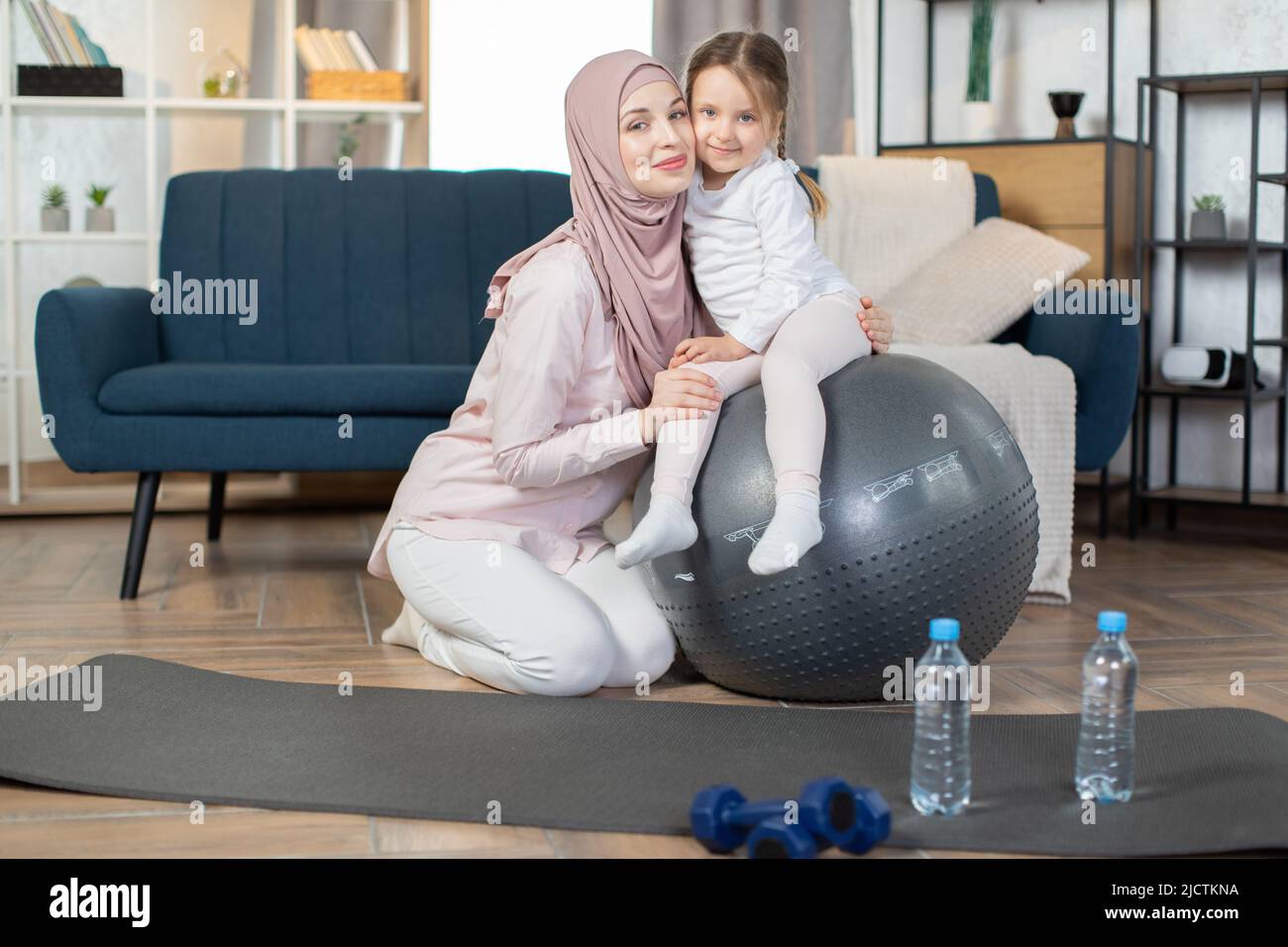 Middle age beautiful muslim sportswoman with her cute little daughter ...