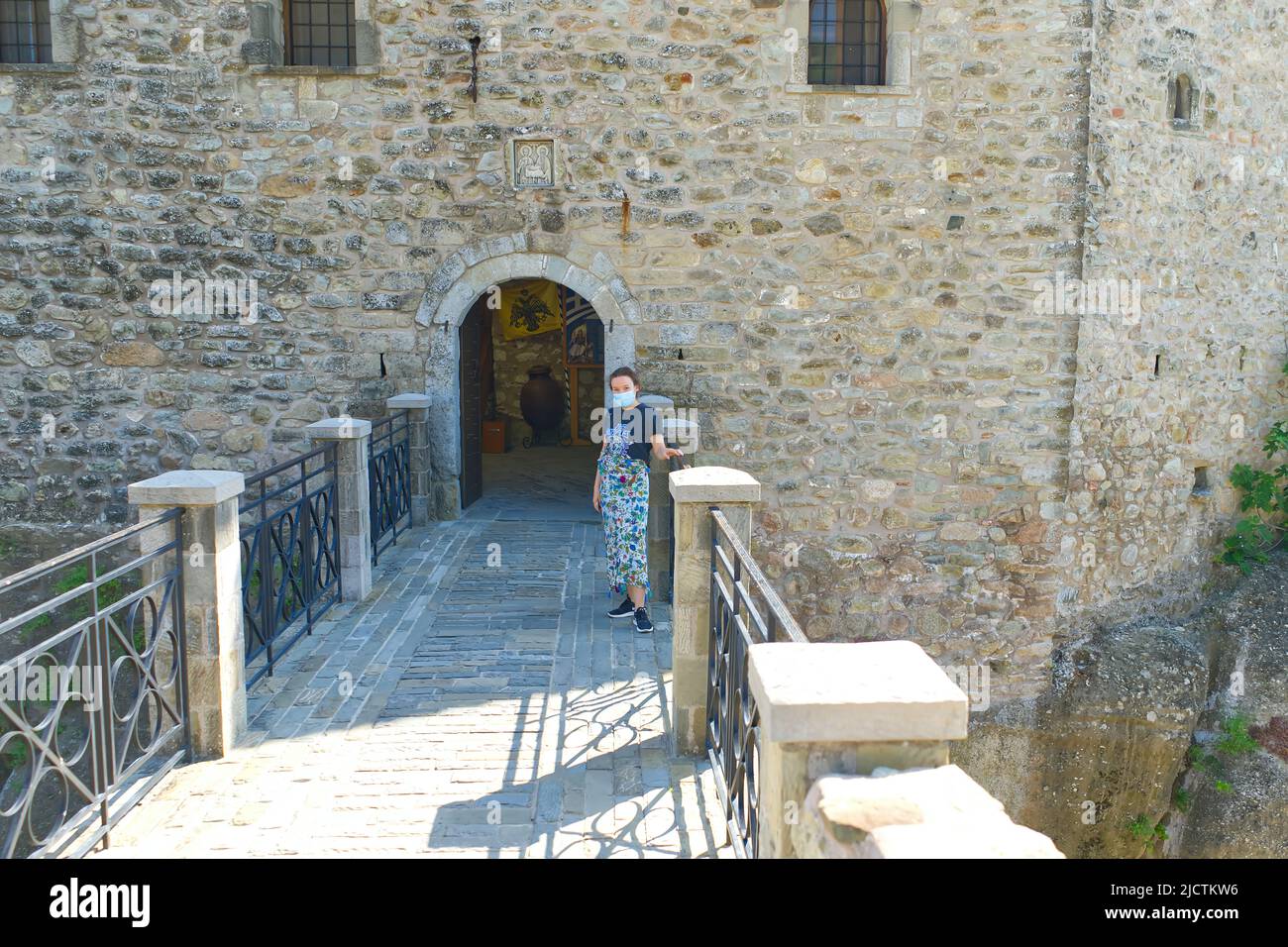 a masked tourist enters the fortress for a tour. Greece, kalabaka Stock ...