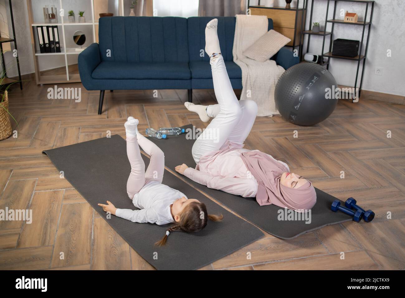 Young positive muslim woman doing stretching flexibility exercises ...