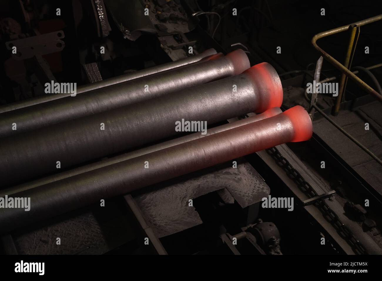 Freshly cast hot cast iron pipes at smelter. Manufacture of pipes for ...