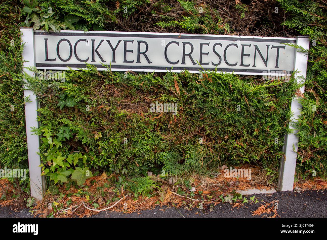 Lockyer Crescent street name sign on two posts with a hedge in the ...