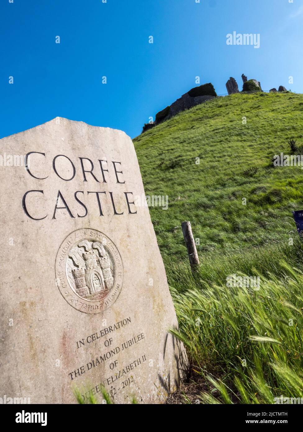 Stone marker for Corfe Castle, Dorset, UK with the castle rising in the ...