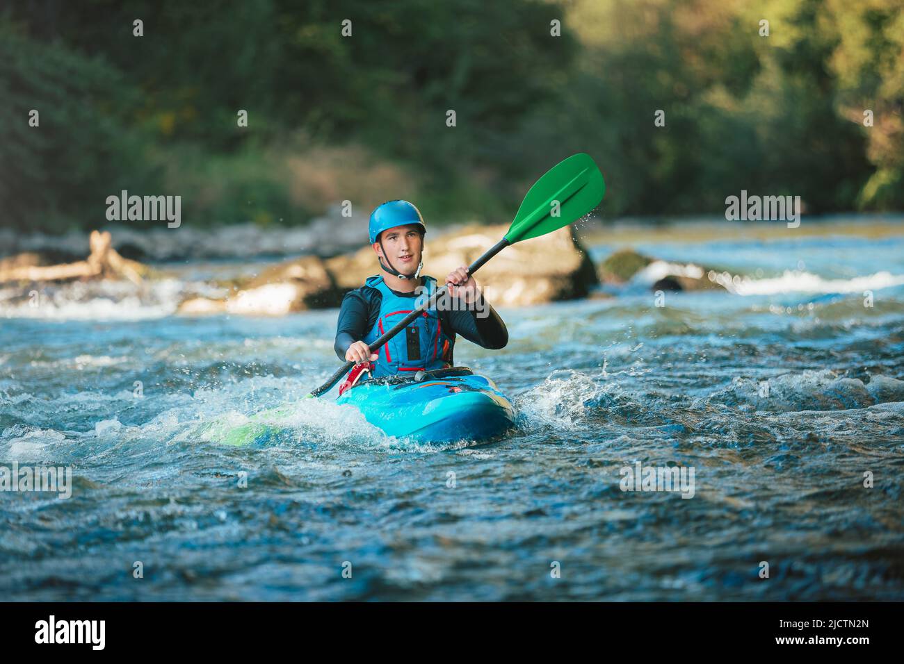 Male recreational athlete paddling carefully over the risky, foamy, and ...