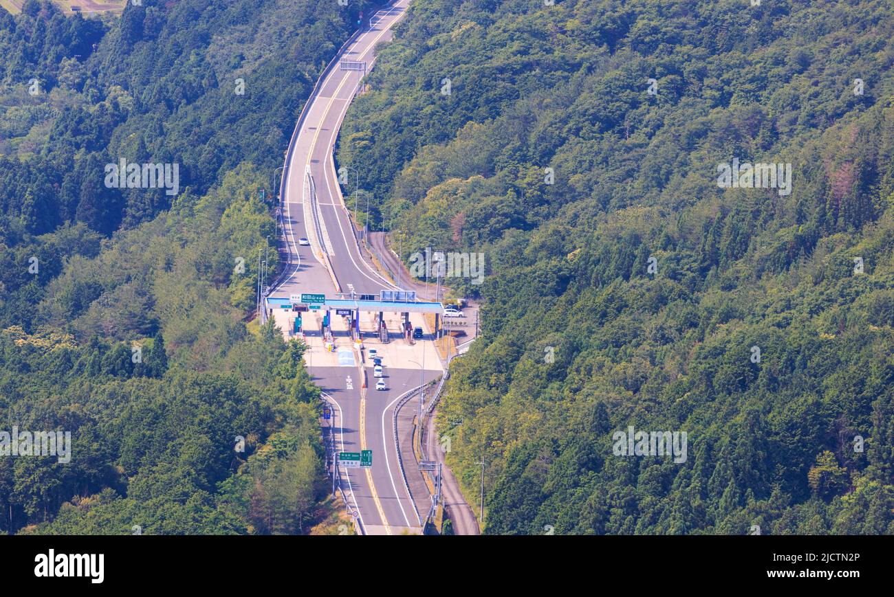 Aerial view of cars driving through toll booth on highway in forest ...