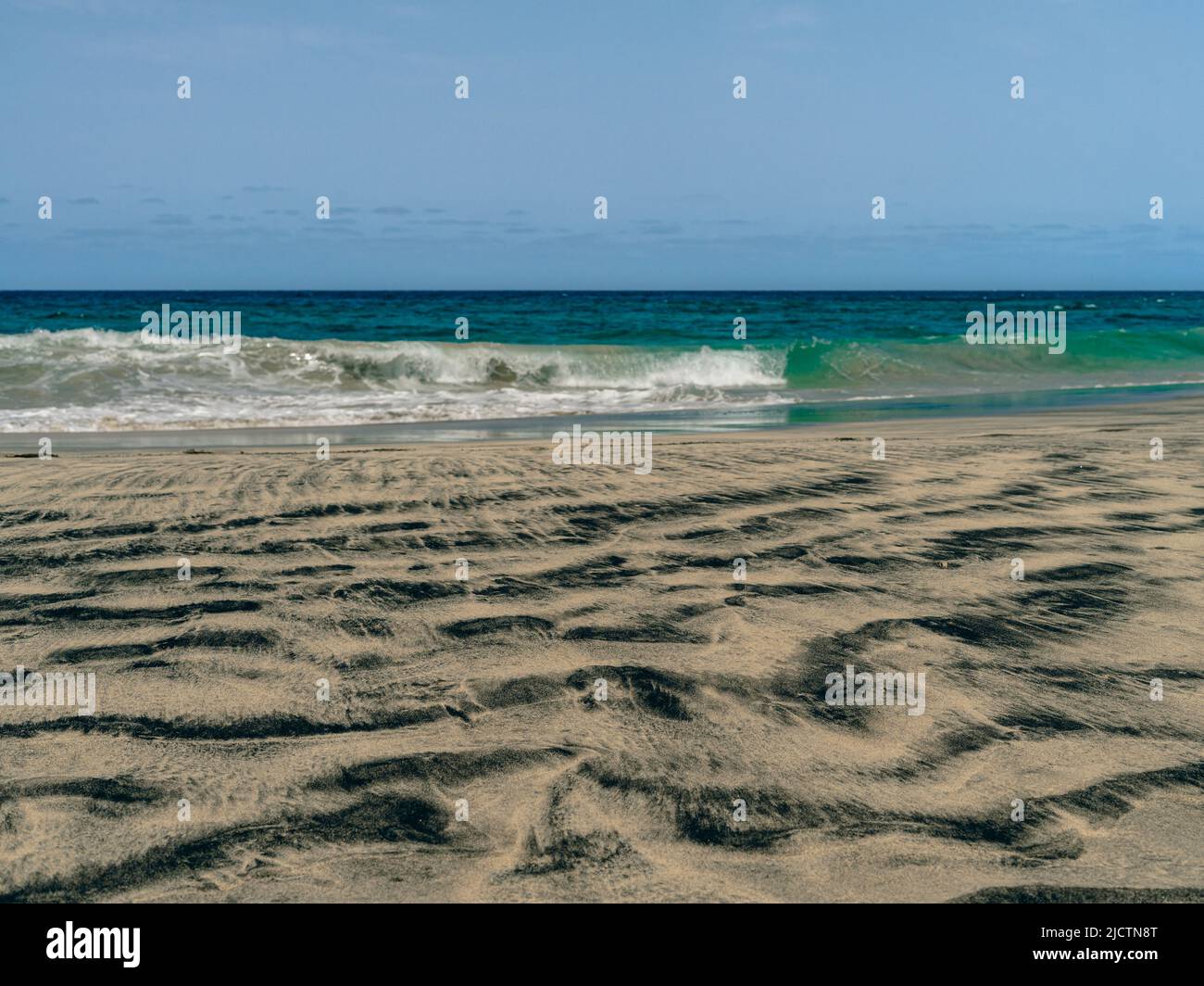 beach with black and white sand and beautiful ocean on the background ...