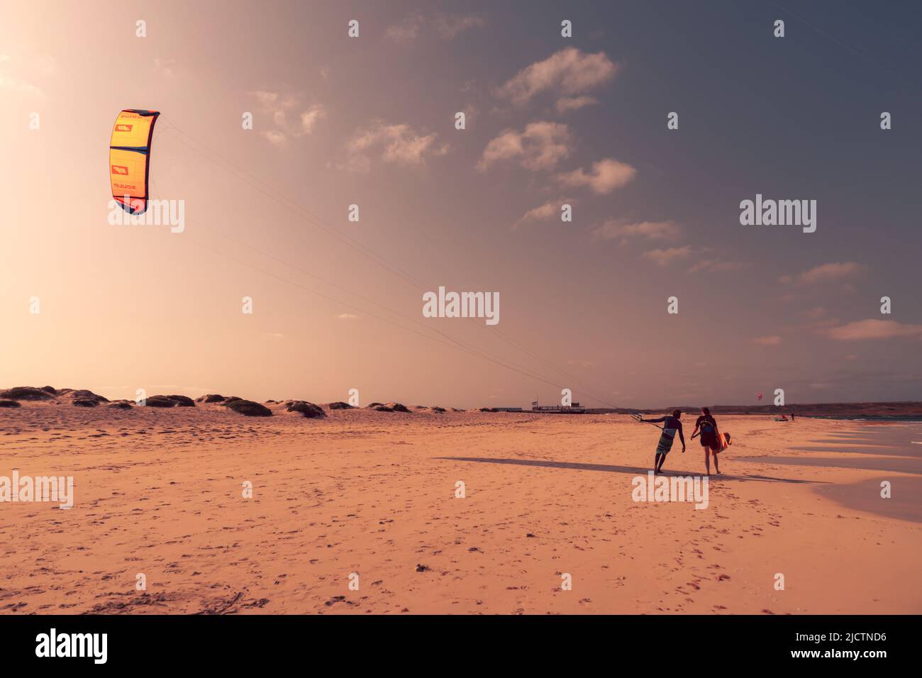 kite surfers walking on beach holding kites Stock Photo - Alamy