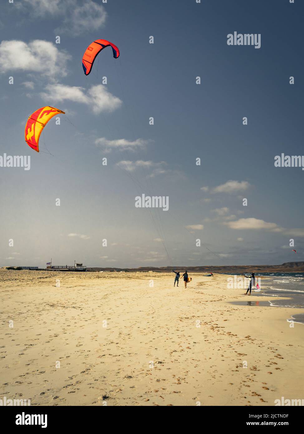kite surfers walking on beach holding kites Stock Photo - Alamy