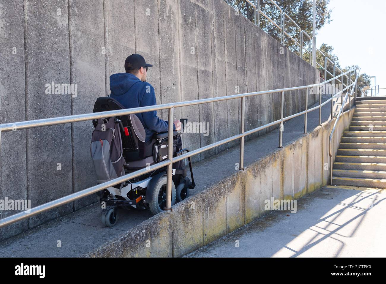 Man on a wheelchair use accessible ramp Stock Photo - Alamy