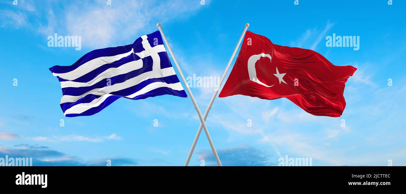 two crossed flags Greece and Turkey waving in wind at cloudy sky ...