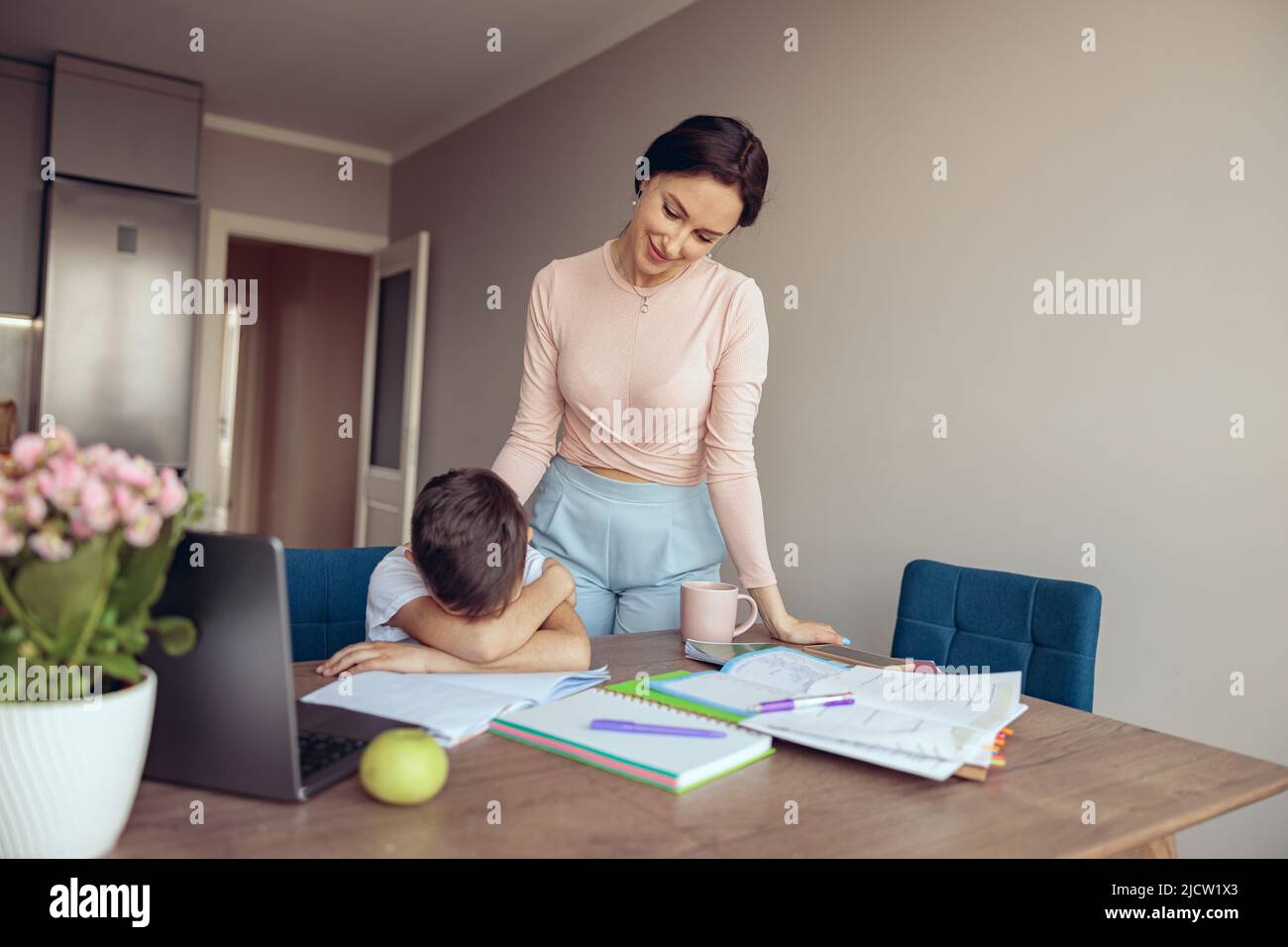Tired das small boy sleeping or crying on table while mother checking ...