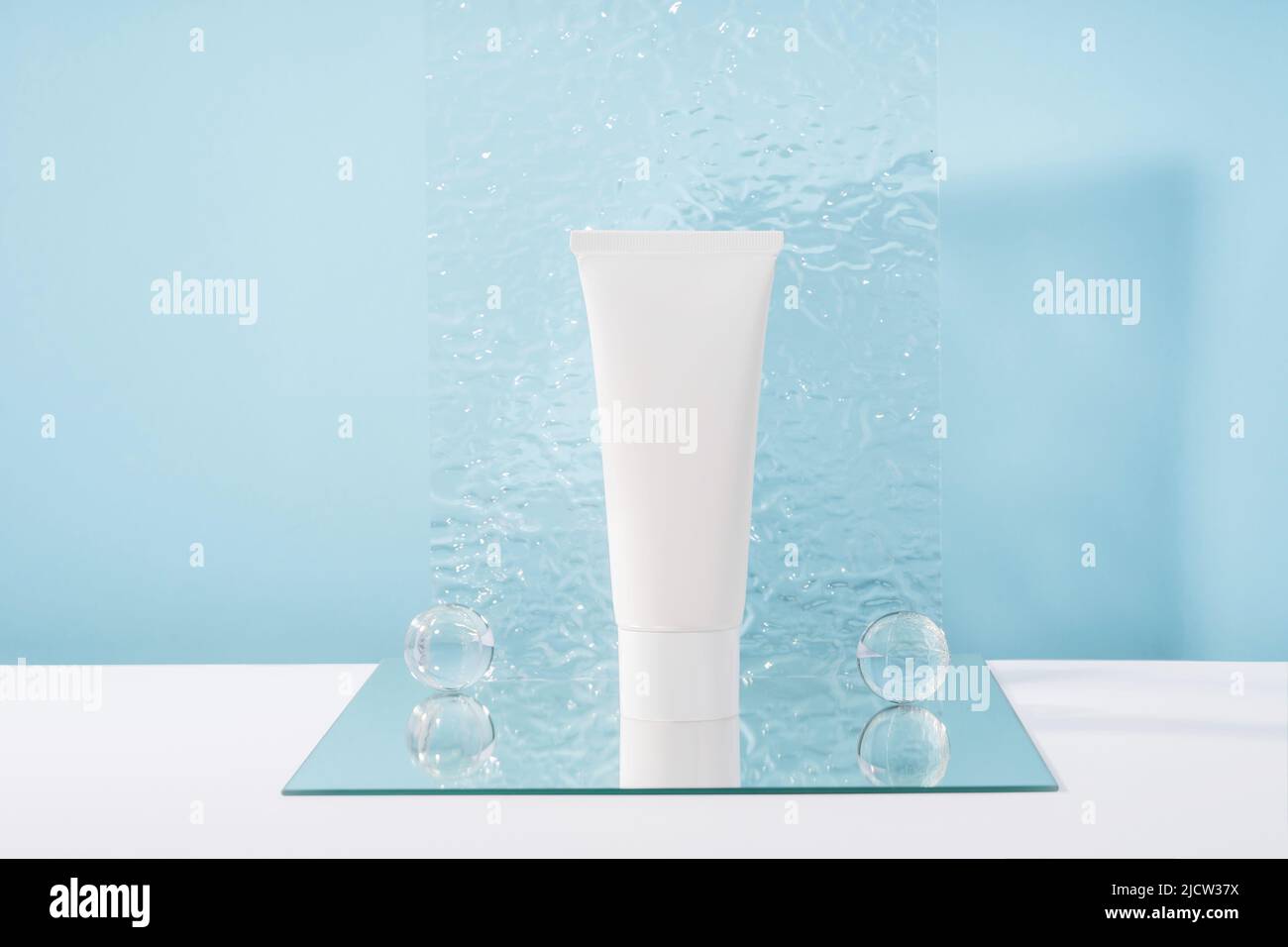 Unbranded cosmetic cream white plastic tube mockup on blue background ...