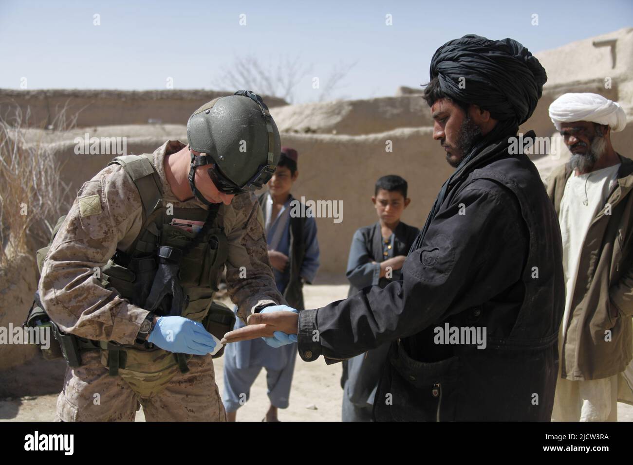 British Royal Marine Commando Lance Cpl. Alan Cahill (left) wipes the ...