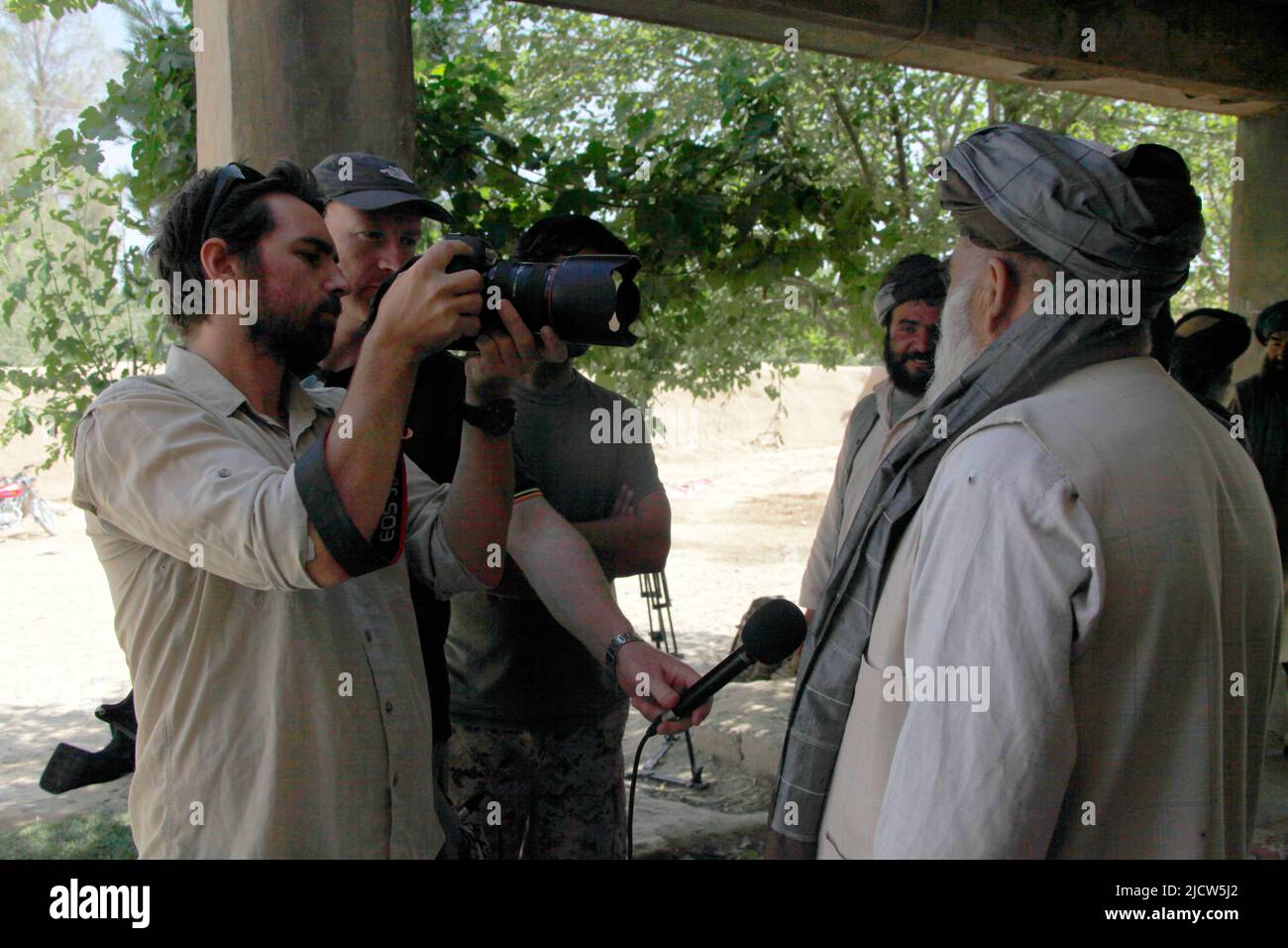 Ben Foley, left, cameraman, and Bernard Smith, center, reporter, with ...