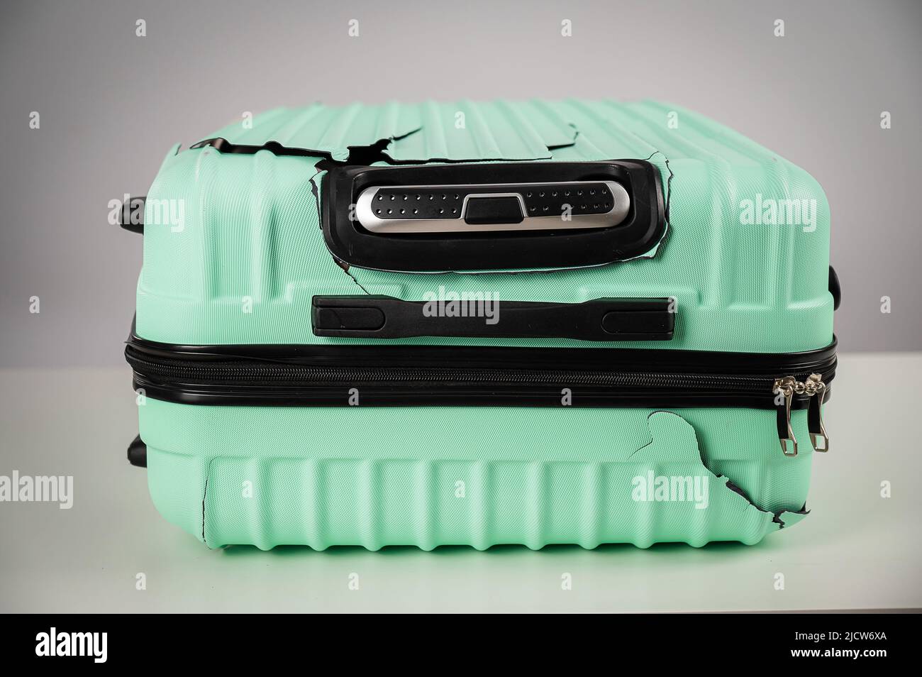 Mint damaged suitcase on a white background Stock Photo - Alamy