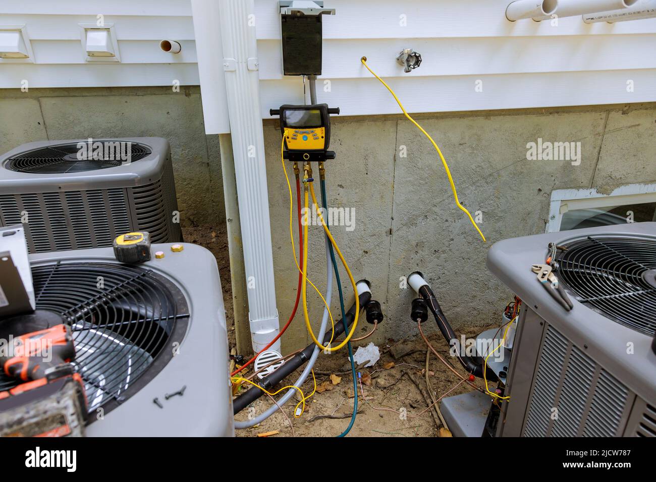 Technician repairing the air conditioner outdoors with multimeter meter ...