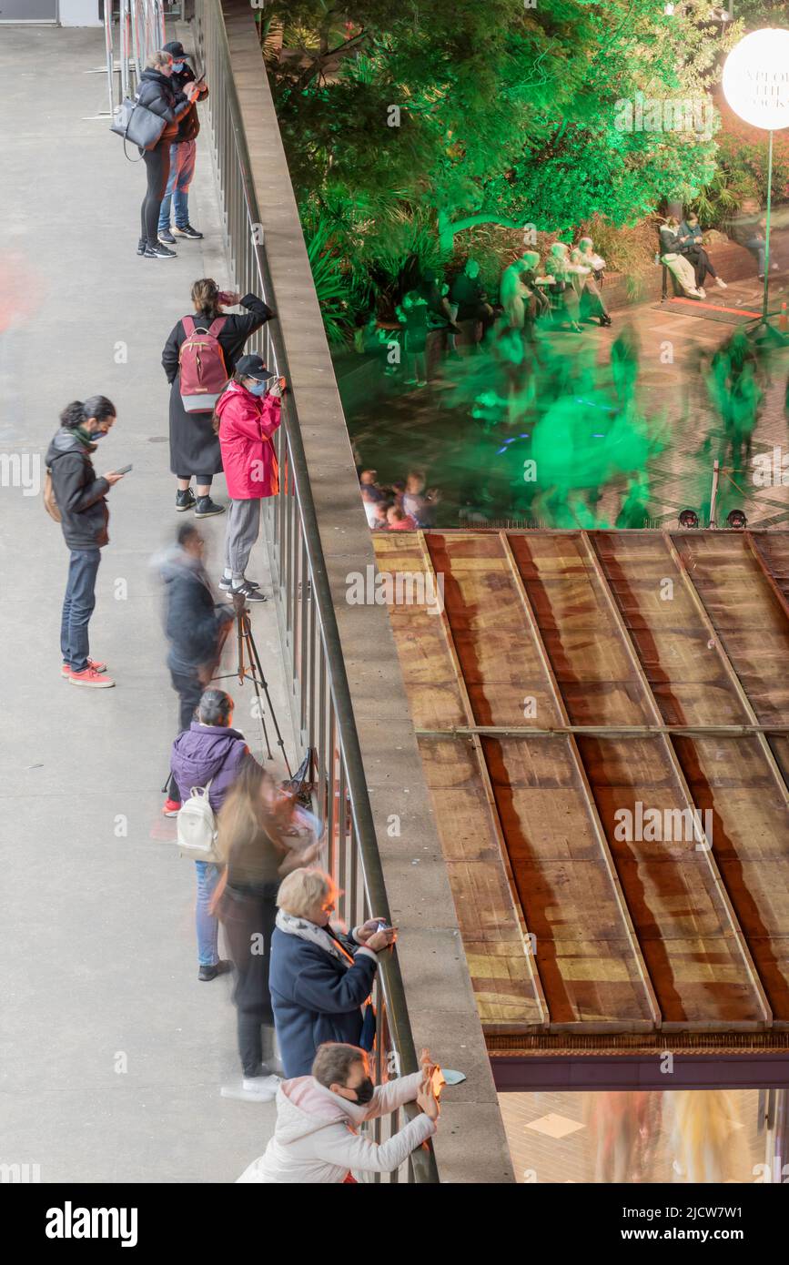 Photographers with cameras and phones line up along the railway ...