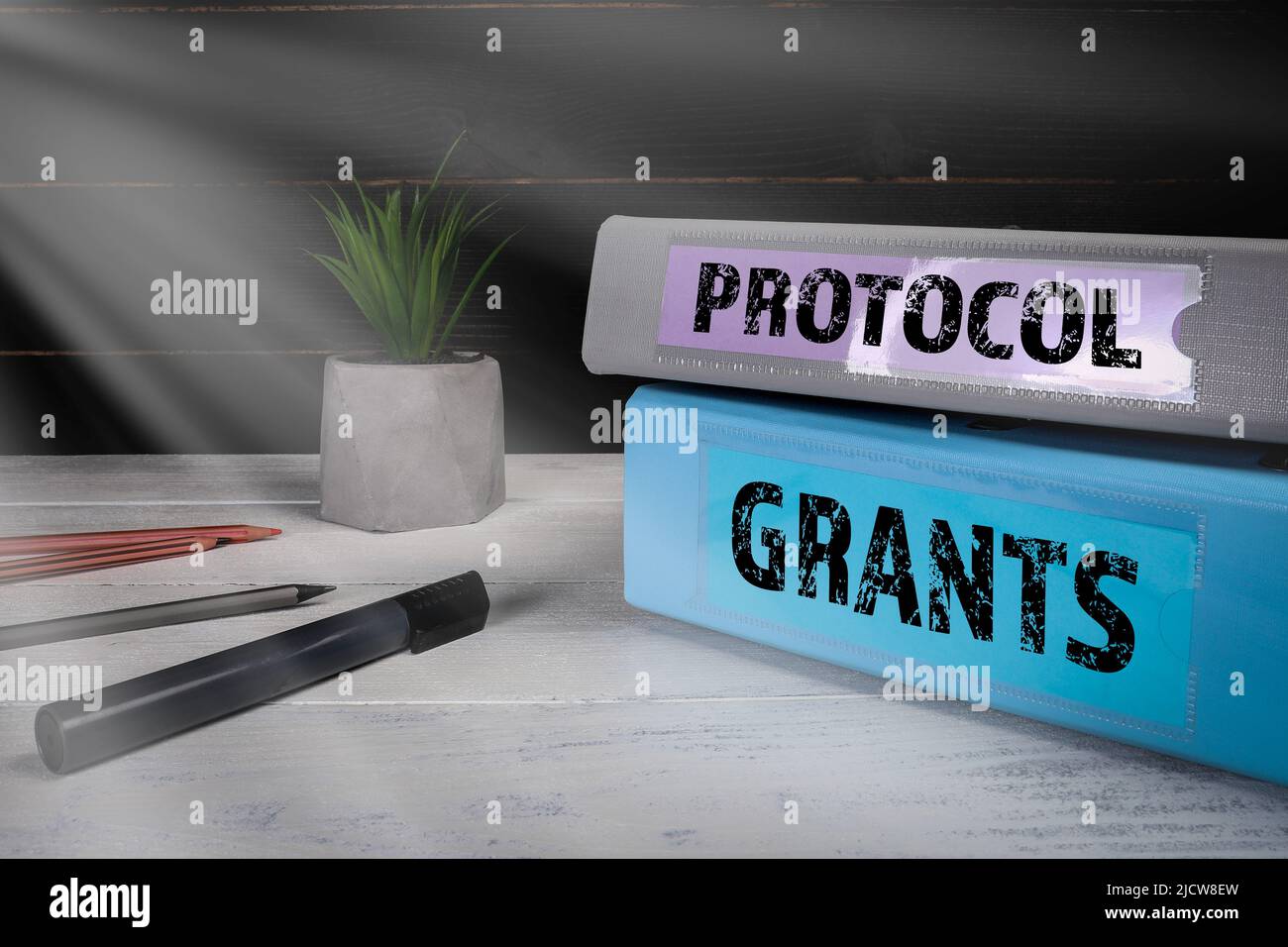 Grants and Protocol. Document folders, binders on a wooden office desk ...