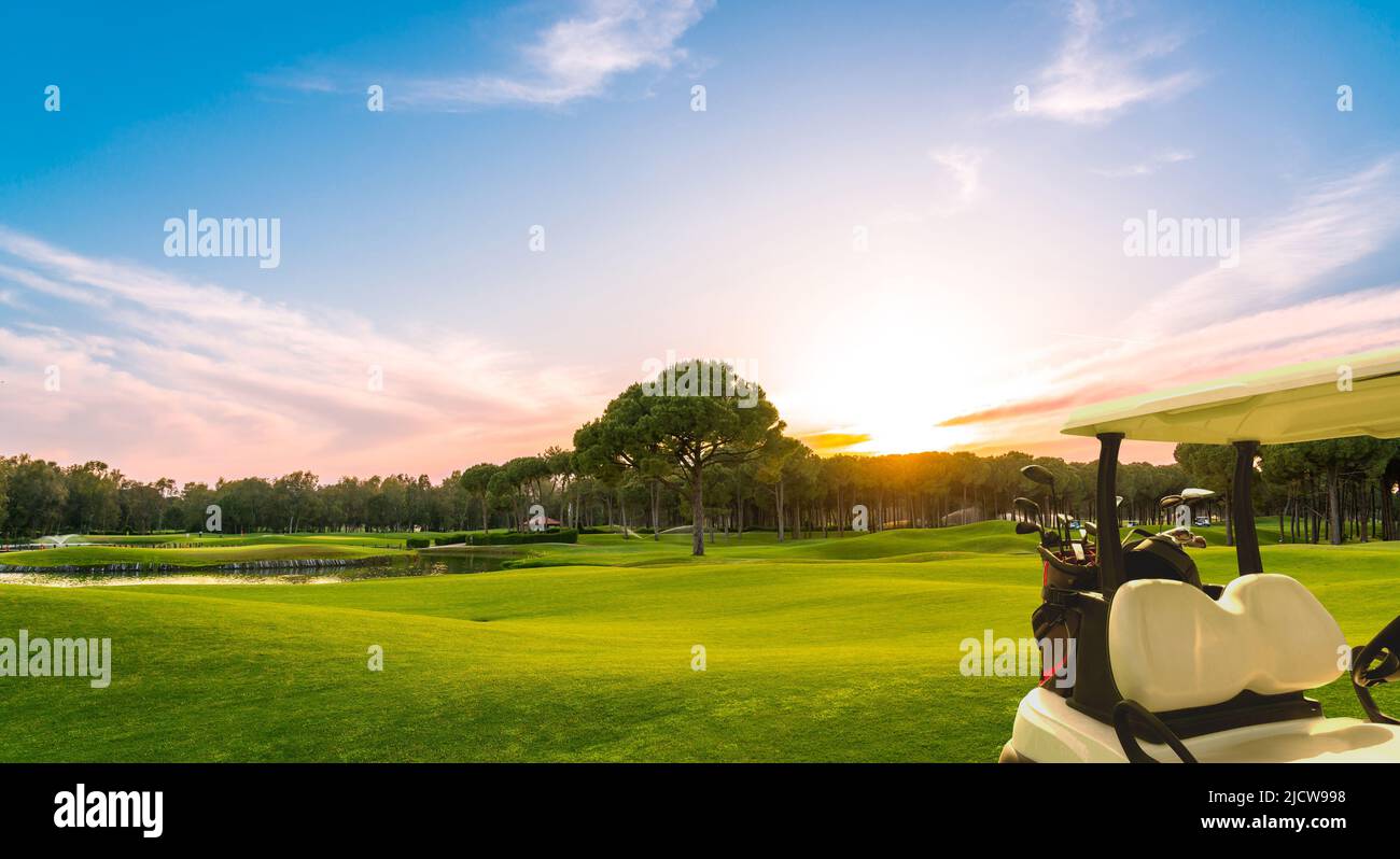 Golf cart on beautiful golf course at sunset Stock Photo - Alamy