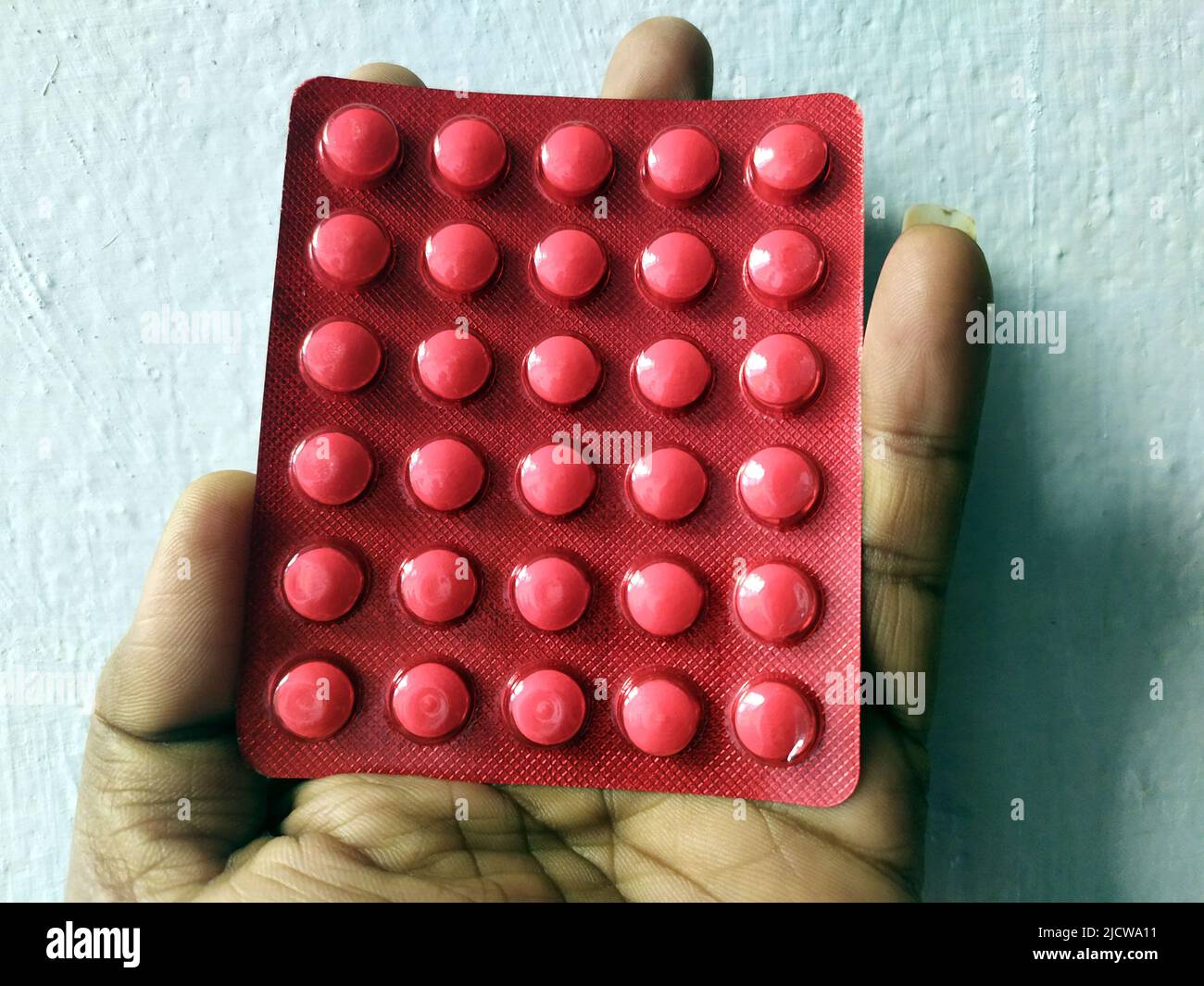 red color medicin pill isolated on stone background Stock Photo - Alamy